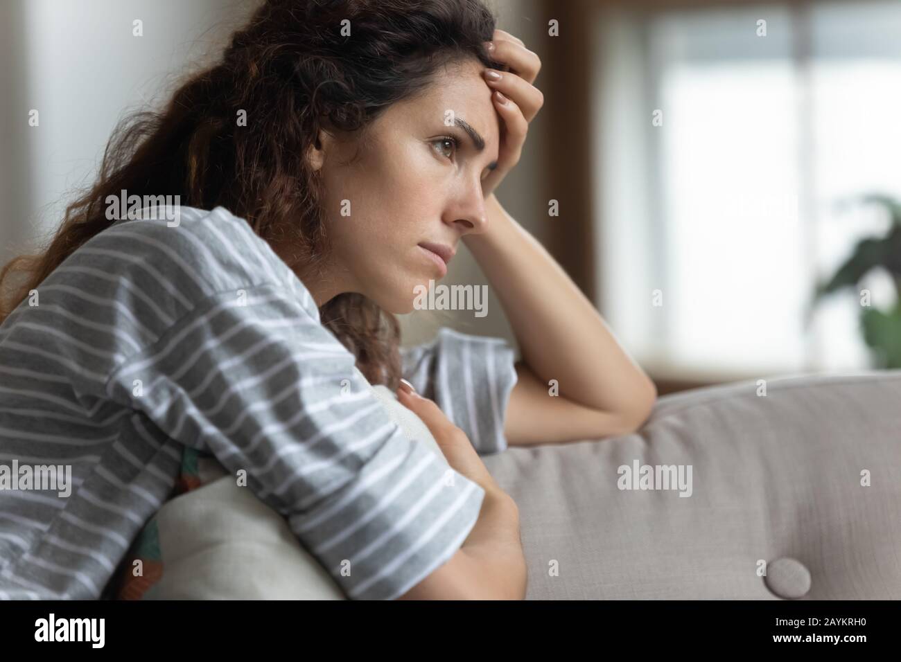 Nervous woman looking away, lost in thoughts alone at home Stock Photo ...