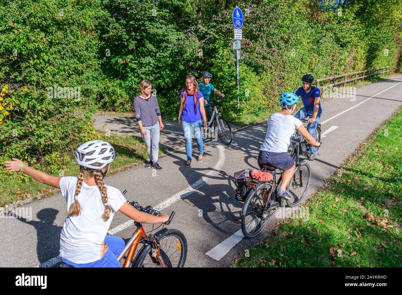 Cyclists and pedestrians travelling together on a cycle and footpath ...