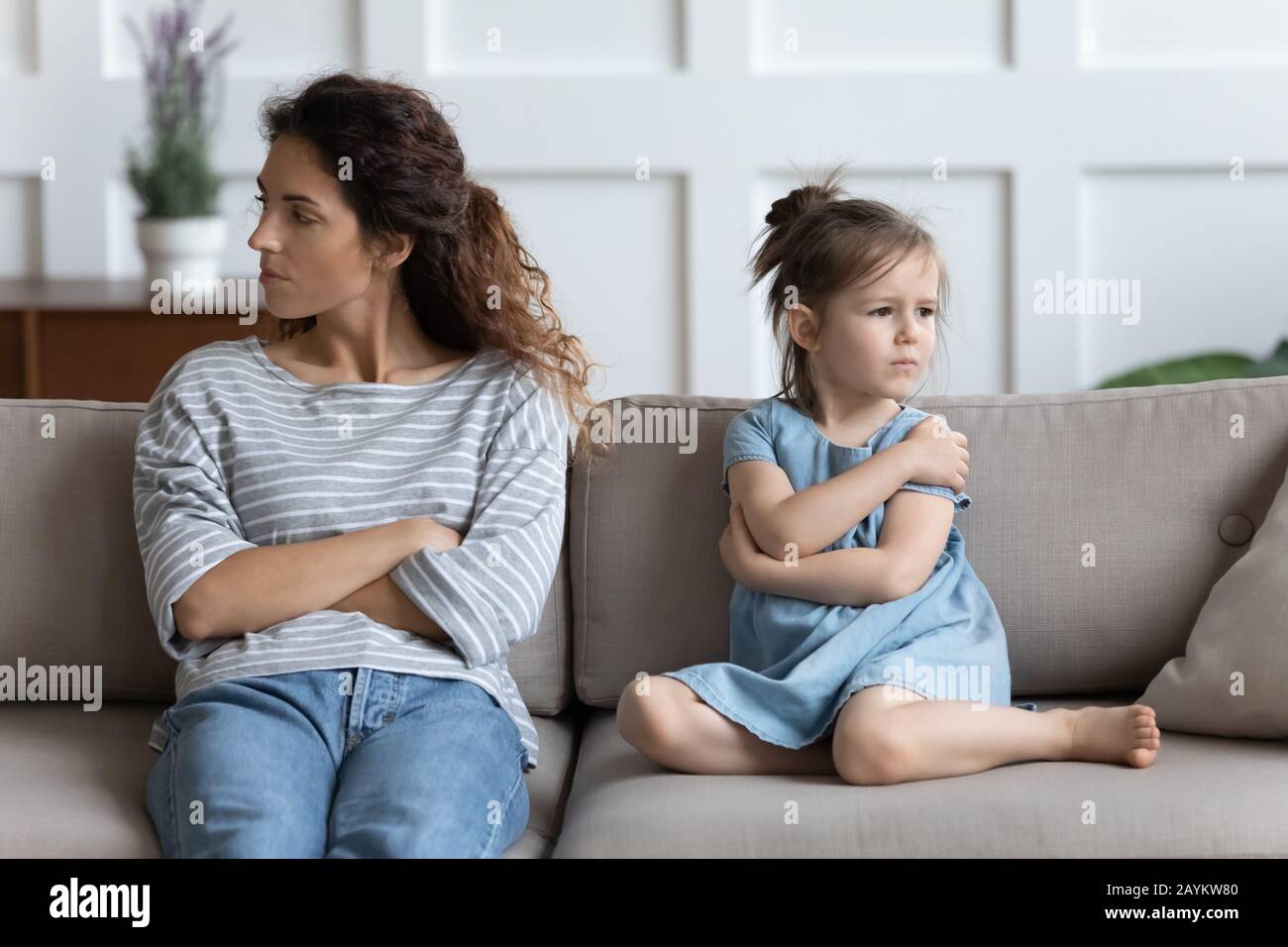 Stressed young mother ignoring offended little preschool daughter Stock ...