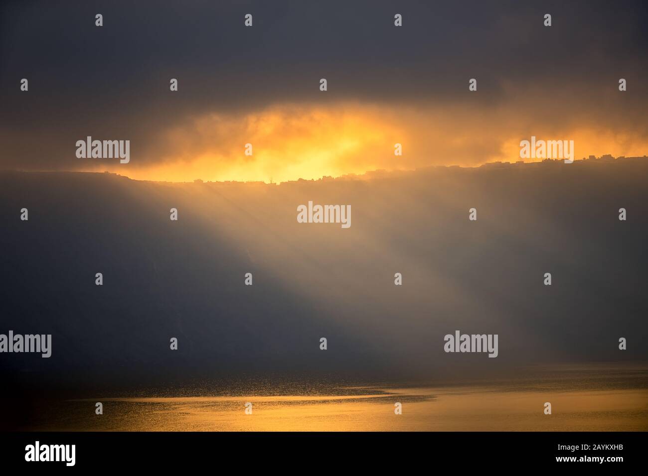 Heavy clouds over the rocky shore. The sun's rays barely break through ...