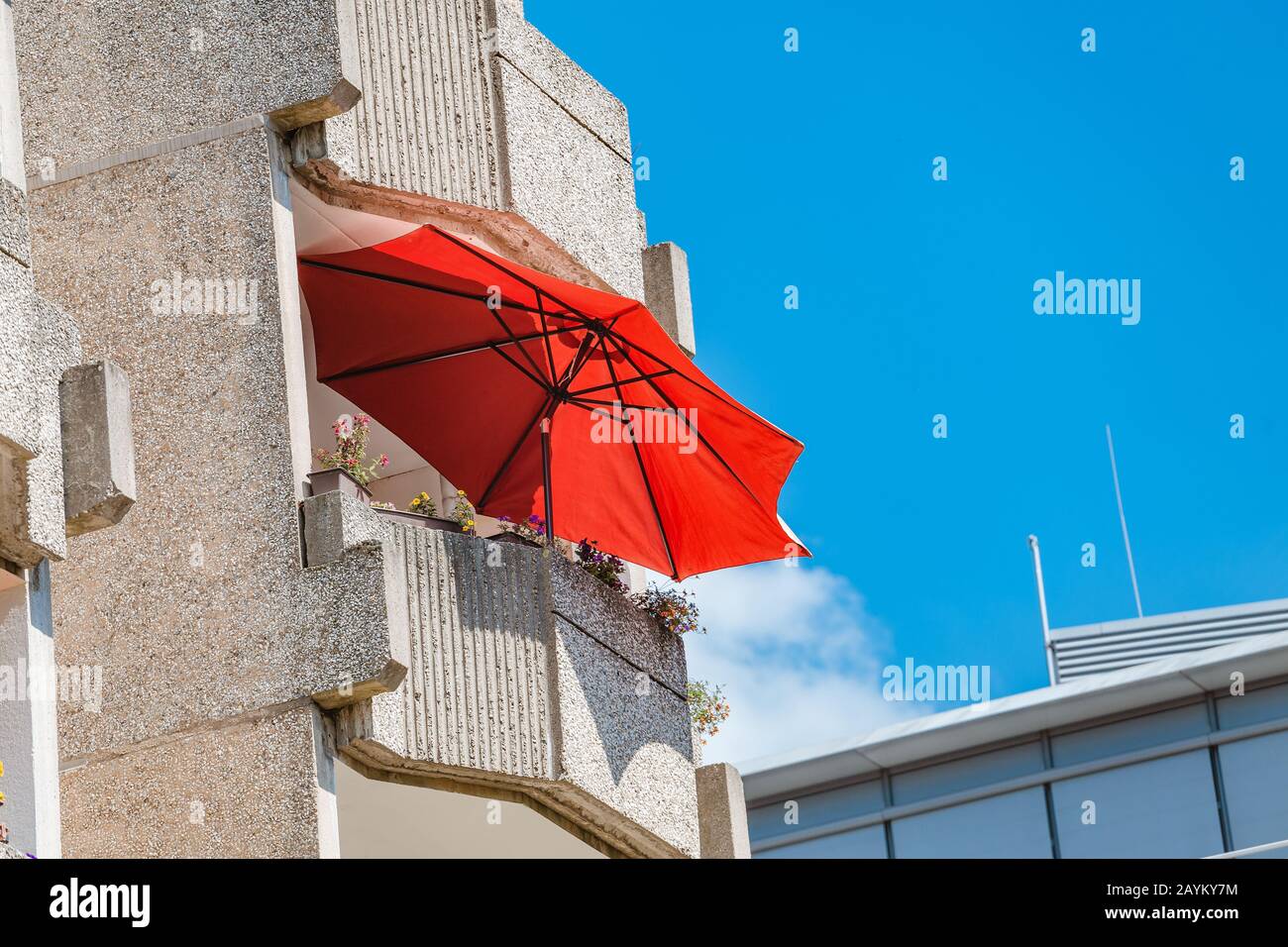 Parasols and umbrellas on the balconies of a tall apartment building in ...