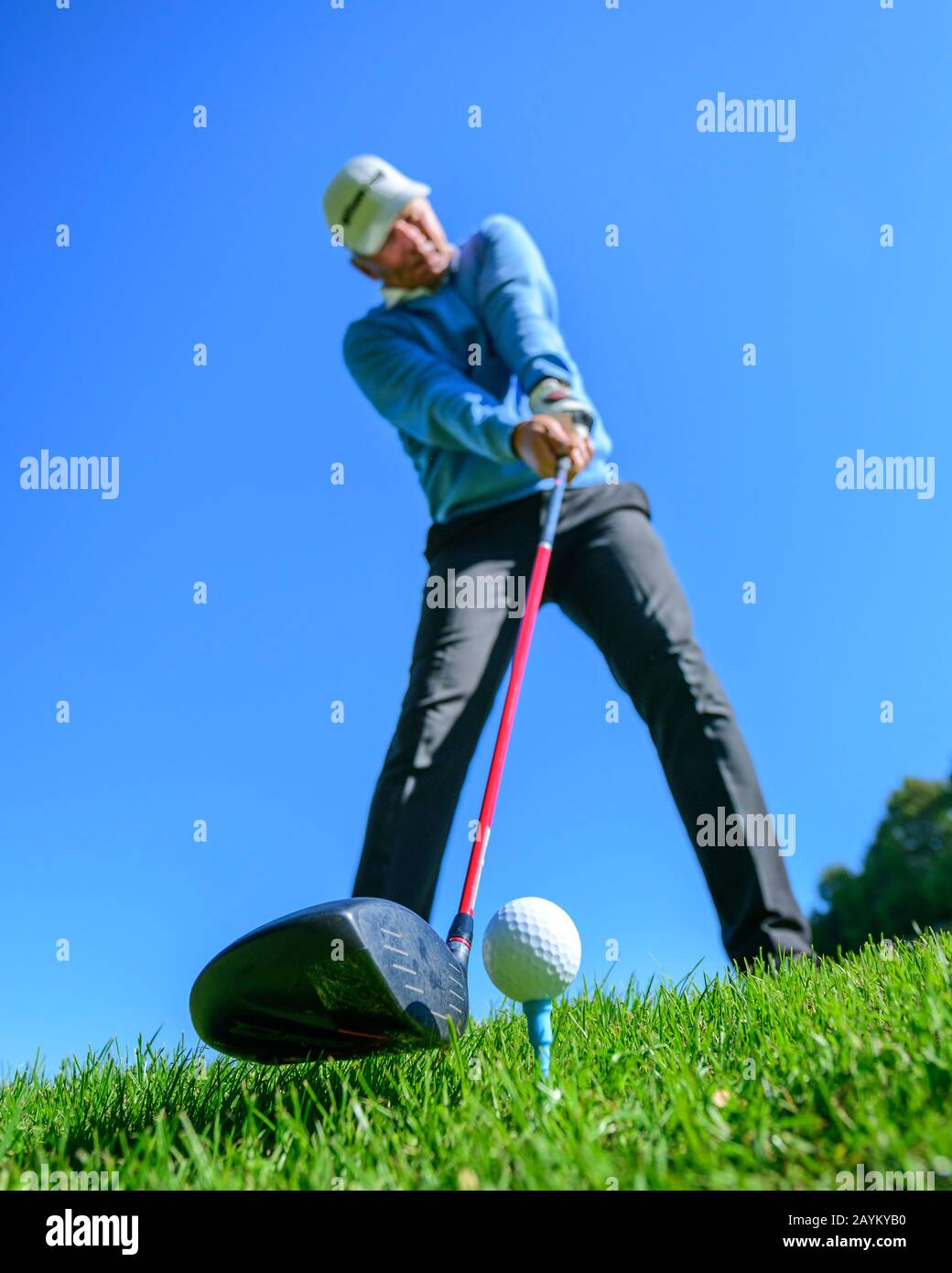 Golf player hitting a ball with driver Stock Photo - Alamy