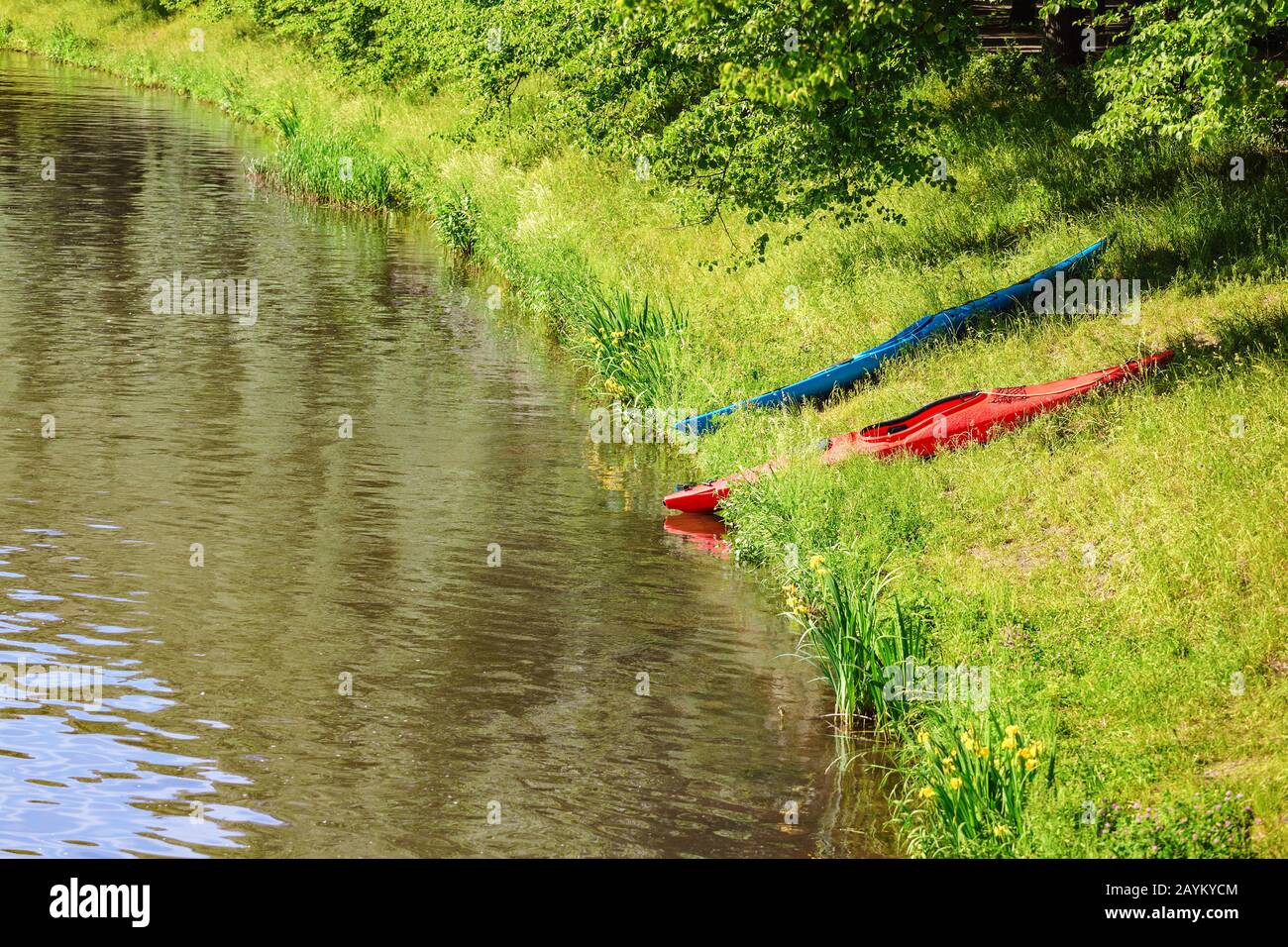 canoes and kayaks on the shore a river or a lake, outdoor activities ...