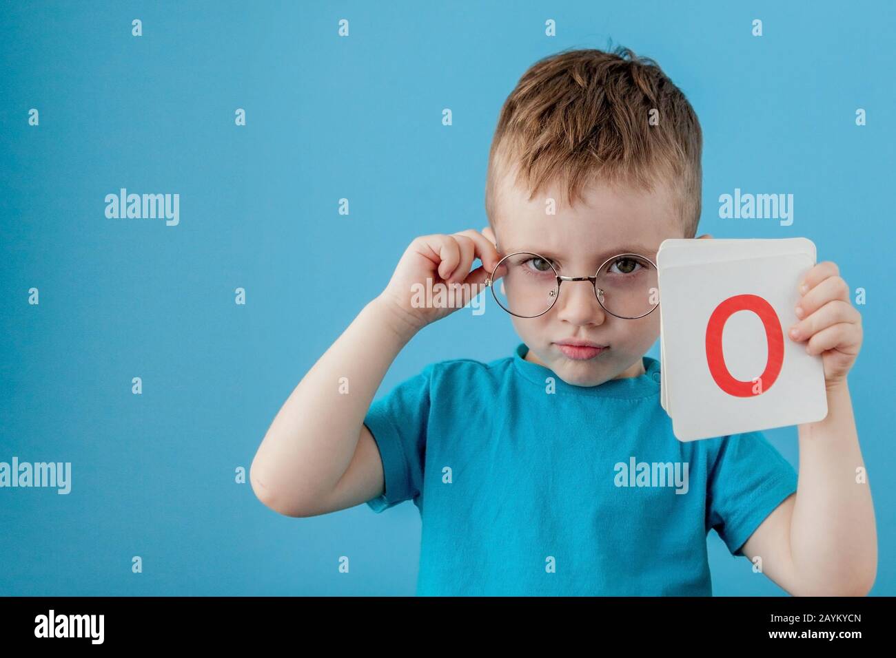 Cute little boy with letter on blue background. Child learning a ...