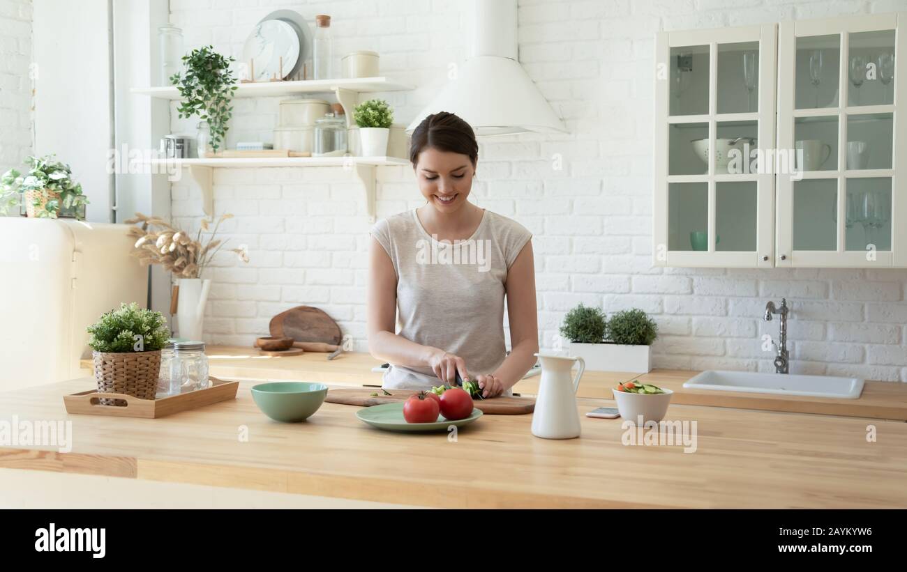 Happy young woman cooking in modern design kitchen Stock Photo - Alamy