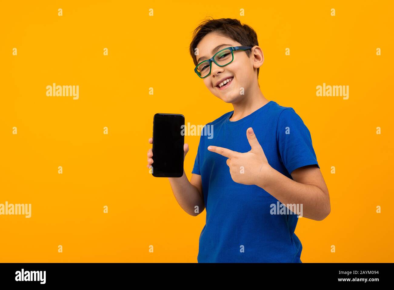 cute boy in glasses holds the phone with the screen forward with the ...