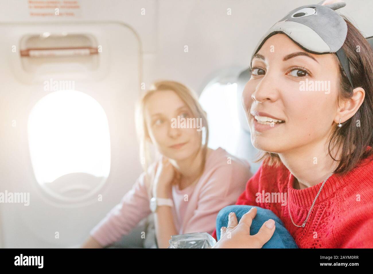 Happy Girlfriends traveling by plane together, air flight passengers ...