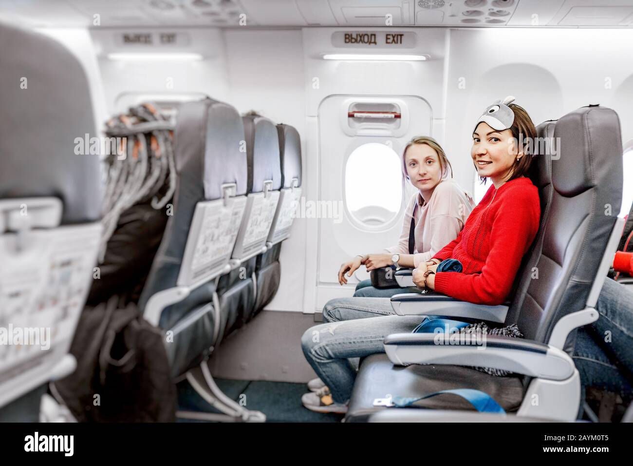 Happy Girlfriends traveling by plane together, air flight passengers ...