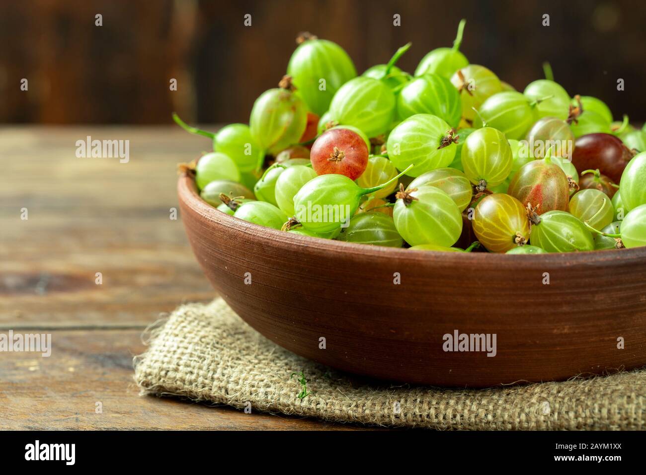 Ripe gooseberry in a clay plate, place for text, top view, summer ...