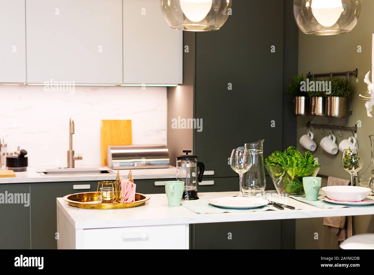 Modern table with utensils and vegetables over kitchen background ...