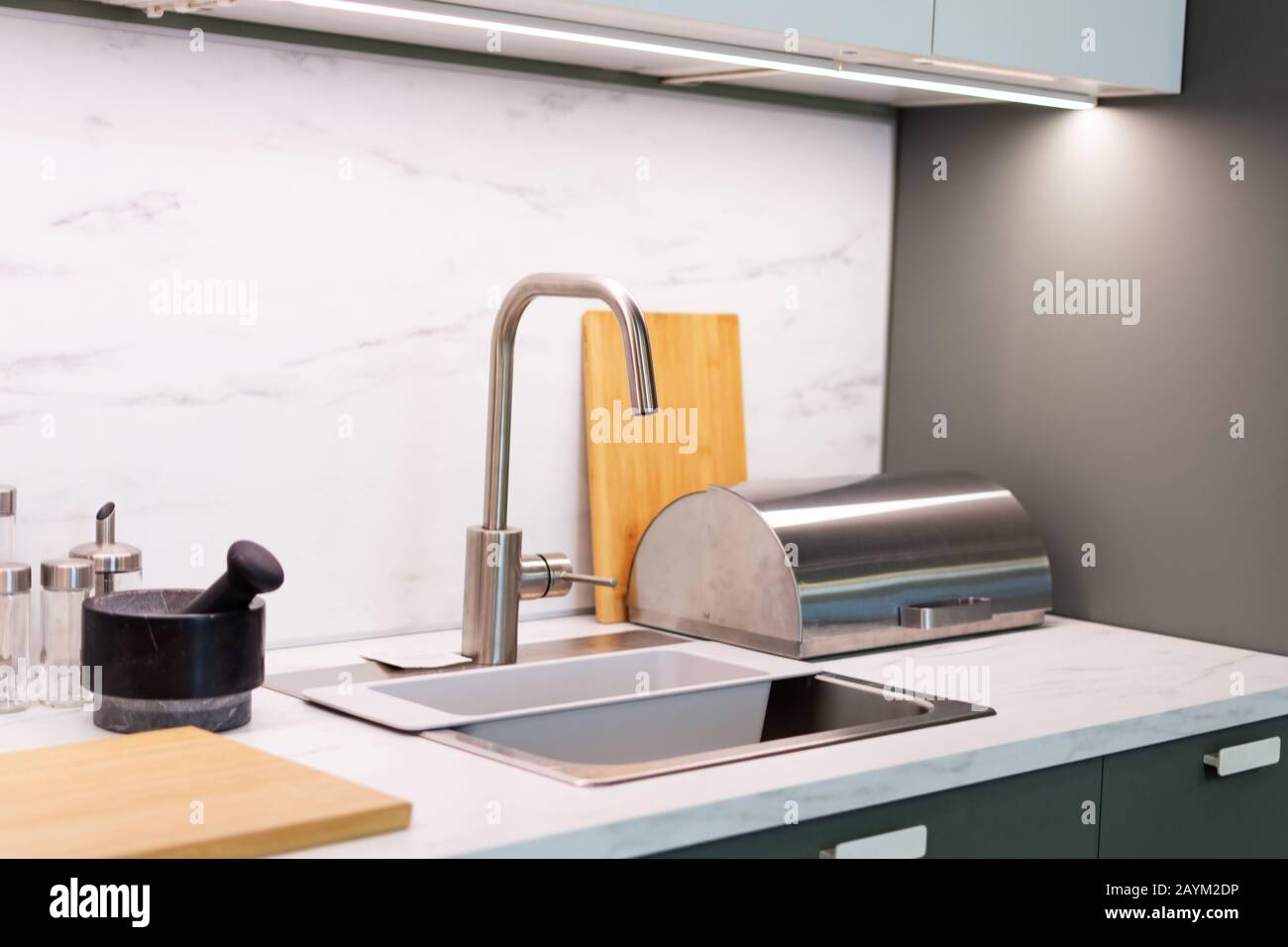 Water tap and sink in a modern kitchen design. Modern kitchen table ...