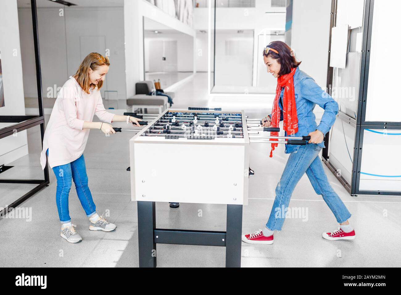 Two girls friends playing table football mini game indoors Stock Photo ...