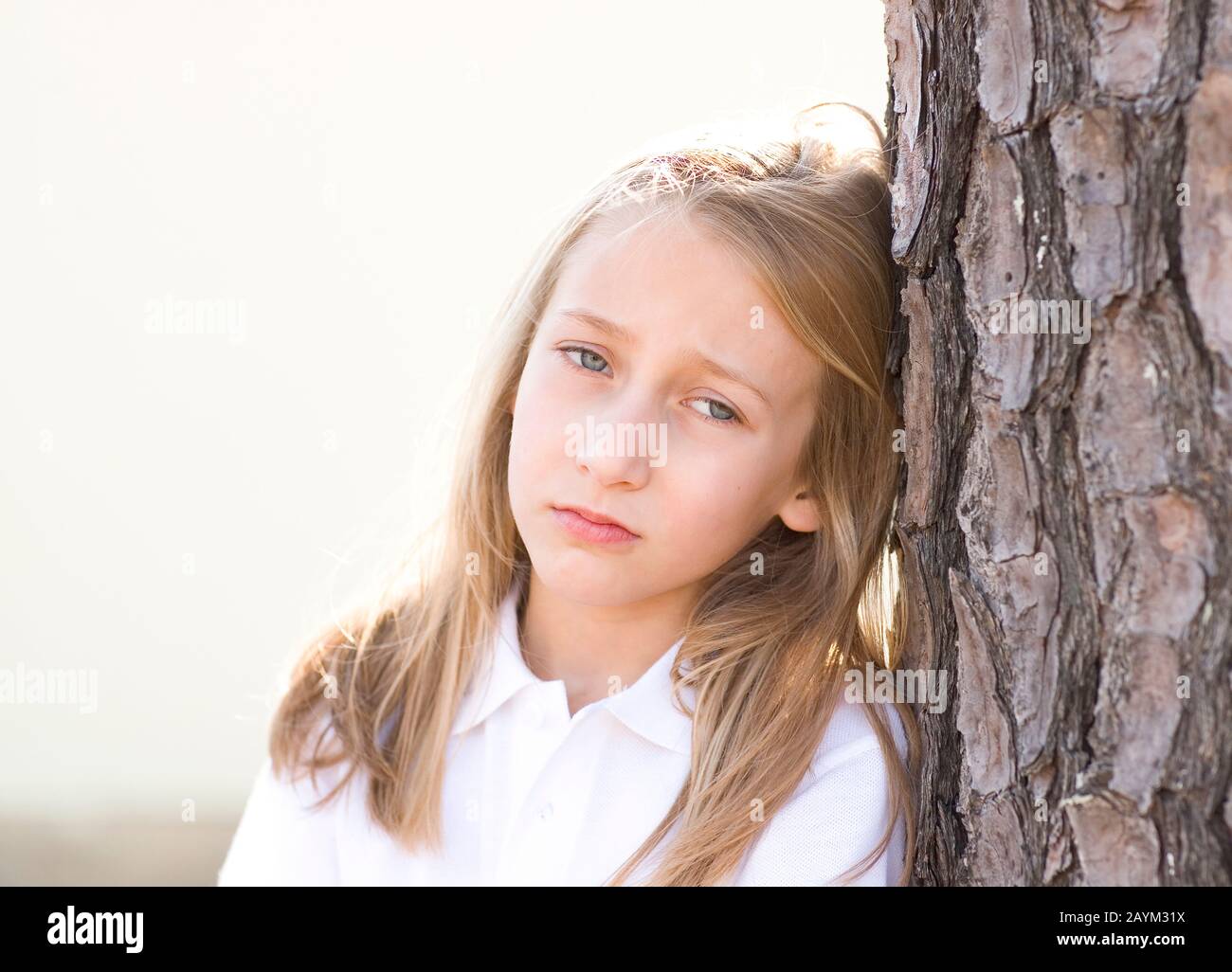 A beautiful young blond haired, blue eyed girl with sad eyes and a ...