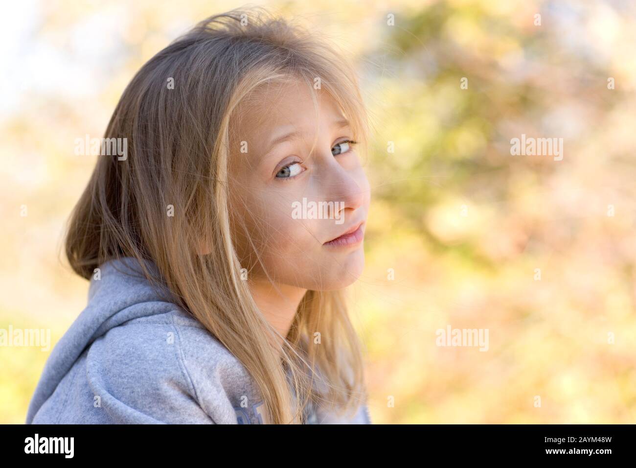 A pretty young girl with blue eyes and tussled blond hair wearing a ...