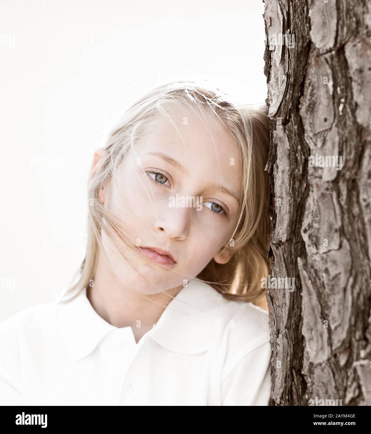 An introspective pretty young blond haired, blue eyed girl with a sad ...