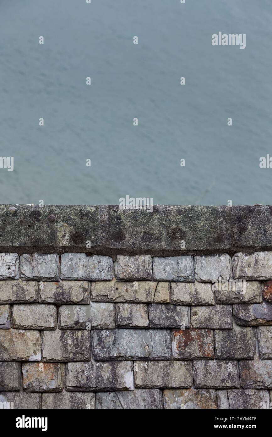 Elevated view of roof with Welsh Slate and ridge tiles with sea in the ...