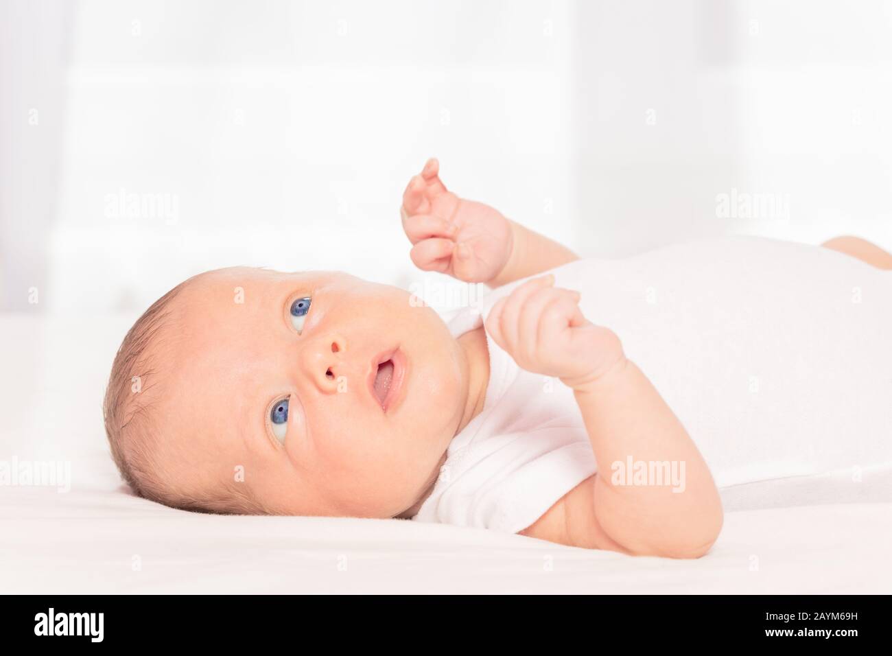 Portrait of newborn infant baby boy laying on the back in the room ...