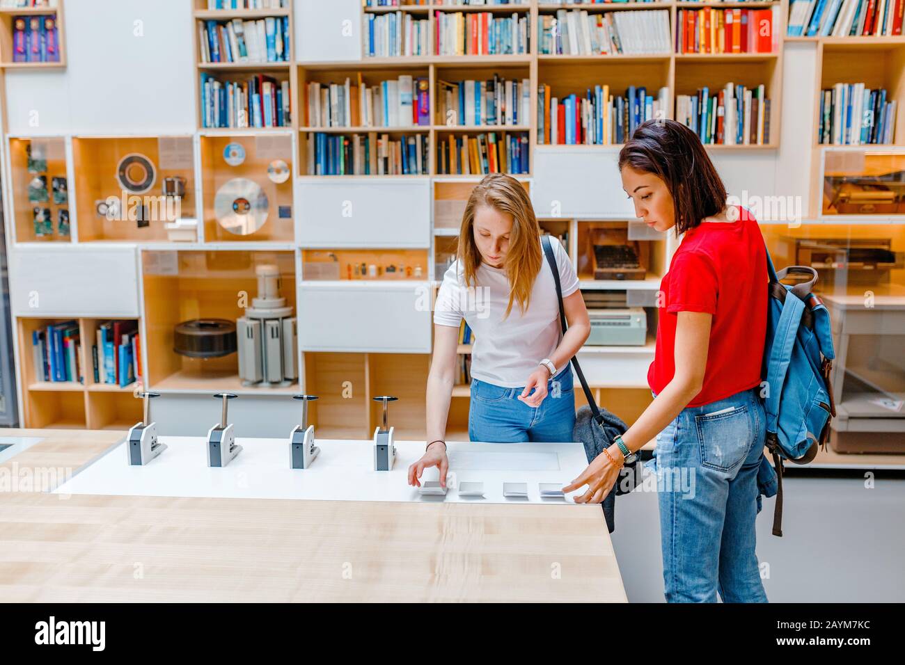 Girl friends students in library Stock Photo - Alamy