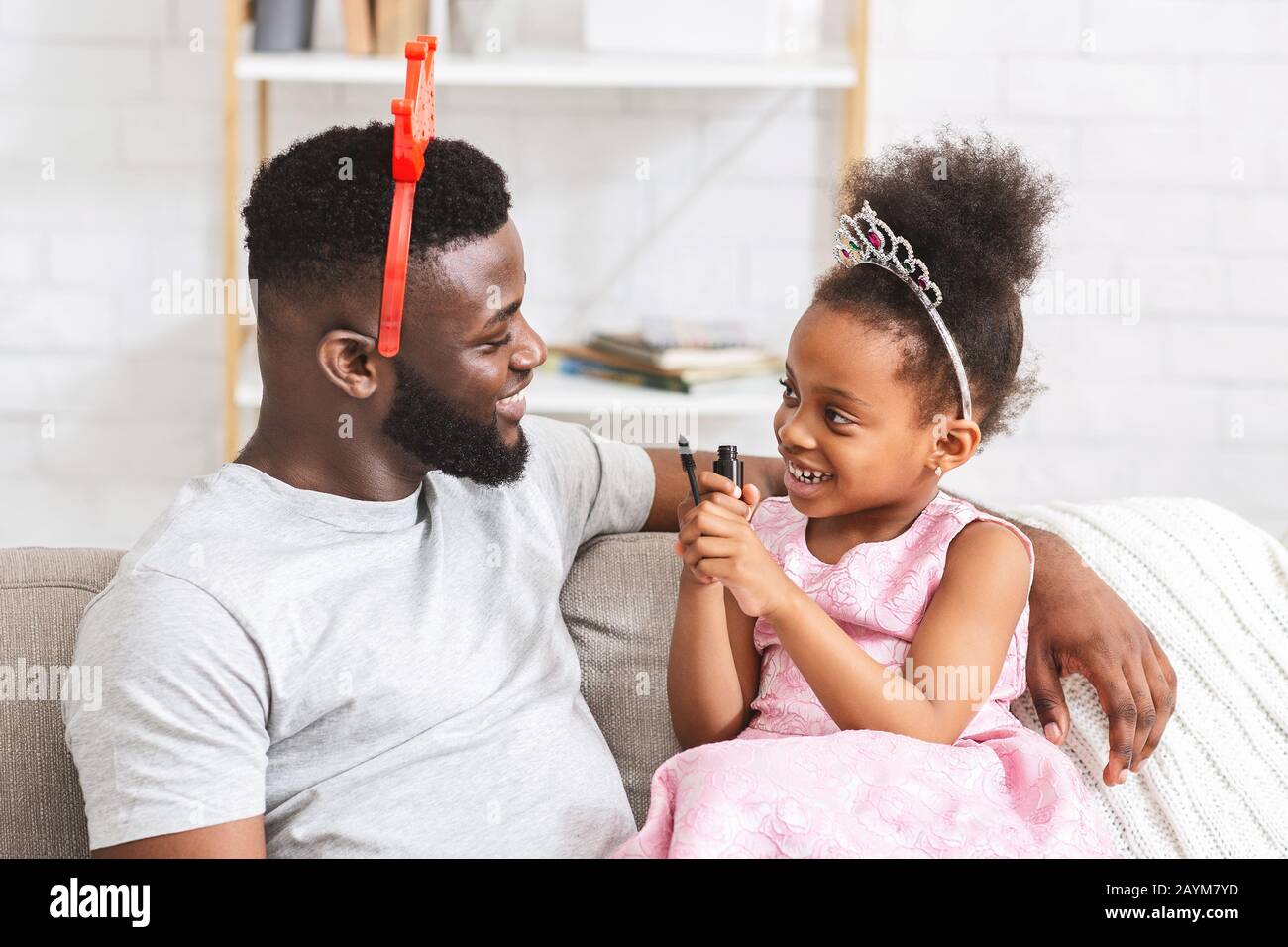 Pretty little girl putting make up on her daddy face Stock Photo - Alamy