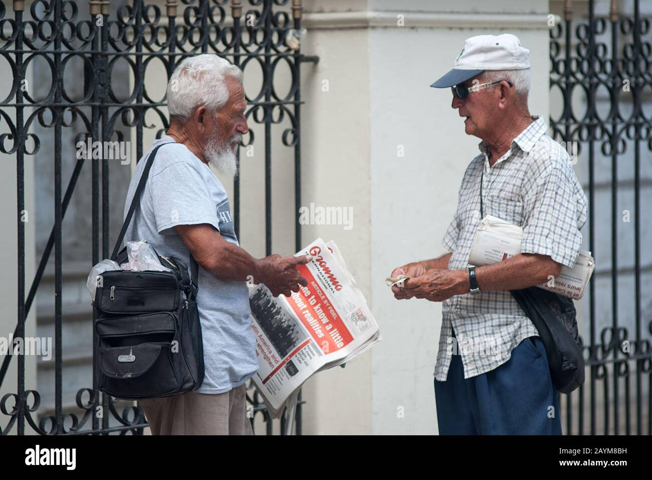 Two cubans with the granma newspaper at Havana. Two people talking ...