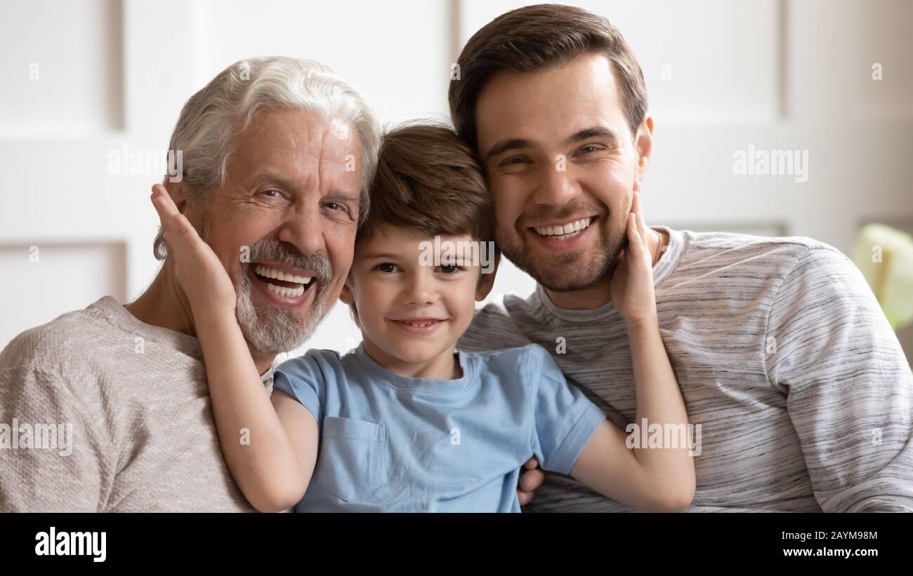 Happy three generations affectionate family looking at camera Stock ...