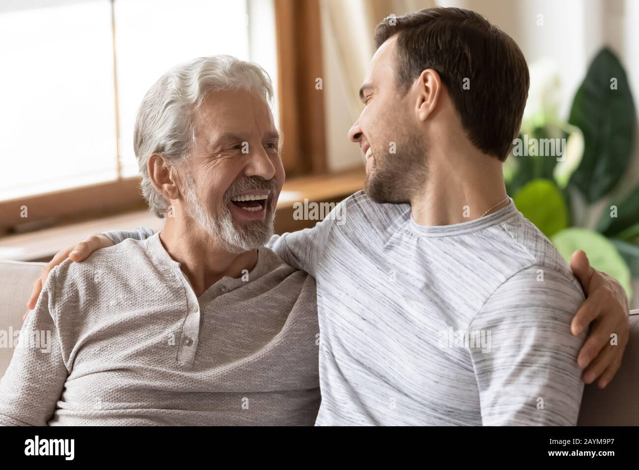 Happy mature old man cuddling shoulders of grownup son Stock Photo - Alamy