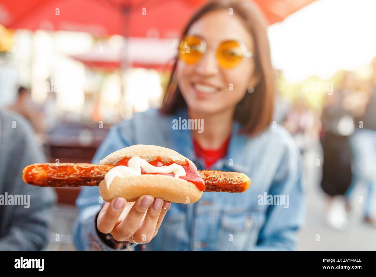 Woman eating Currywurst fast food German sausage in outdoor street food ...