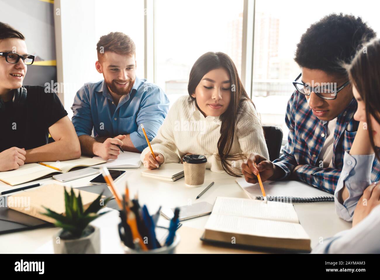 Education concept. College friends doing homework together Stock Photo ...