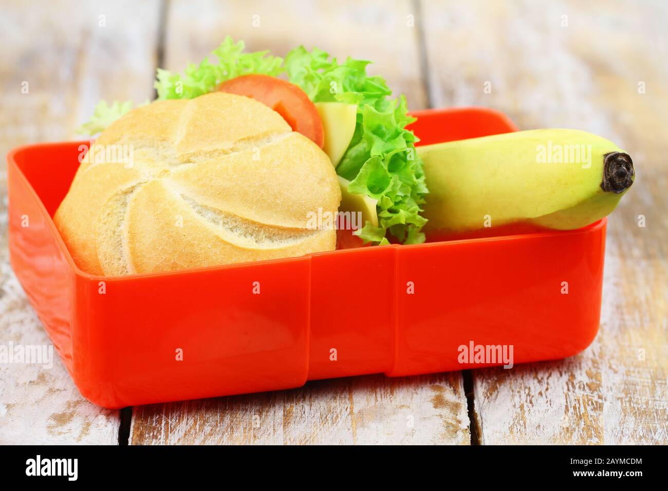 Healthy lunch box containing fresh roll with cheese, lettuce, tomato ...