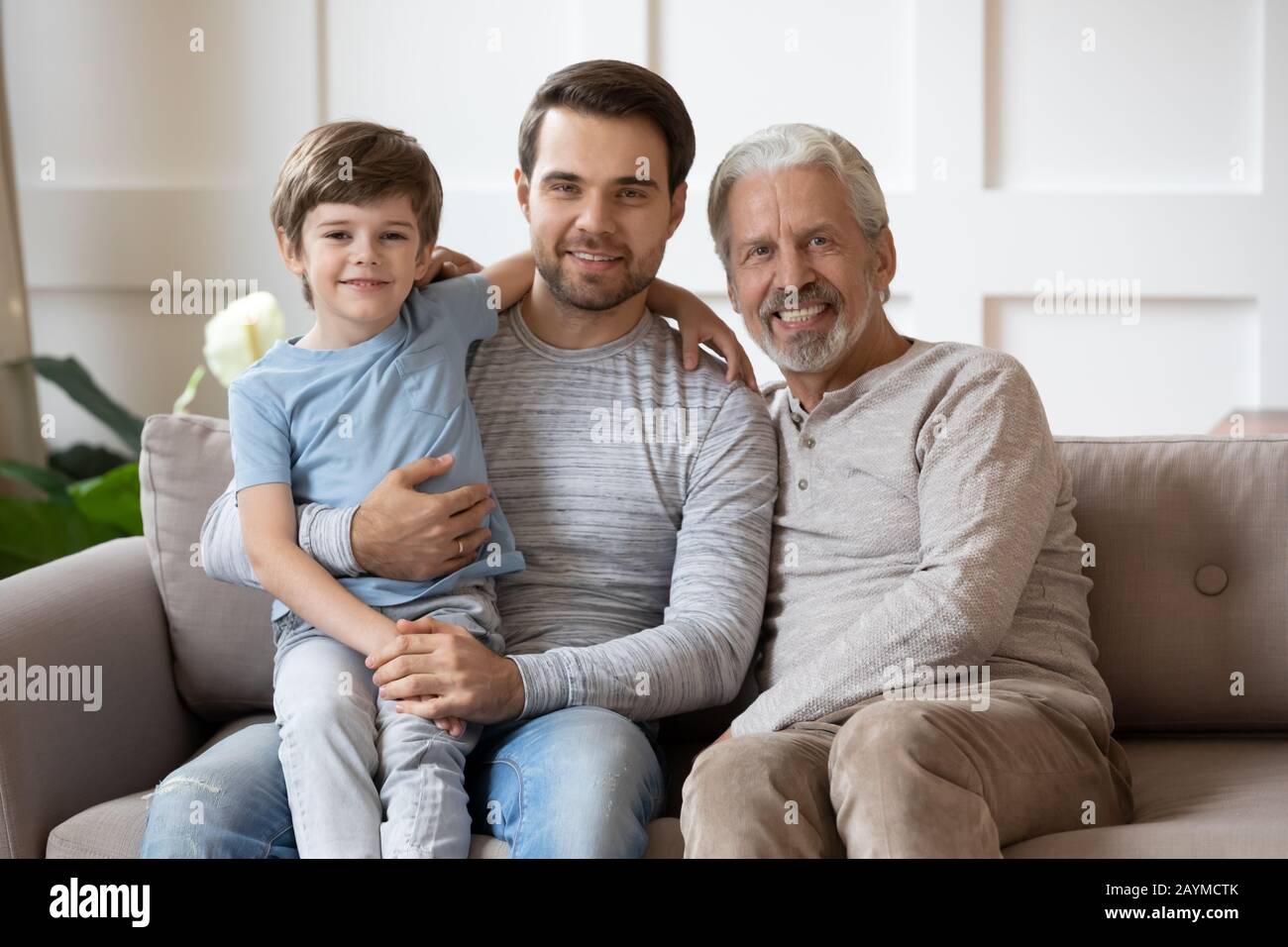 Happy three generations male family resting on couch Stock Photo - Alamy