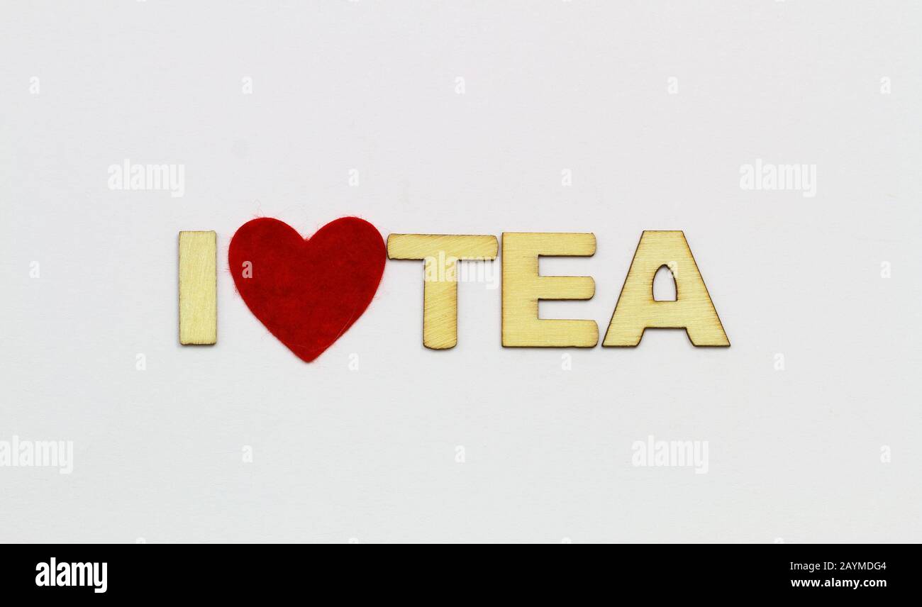I love tea written with wooden letters on white surface and red heart ...