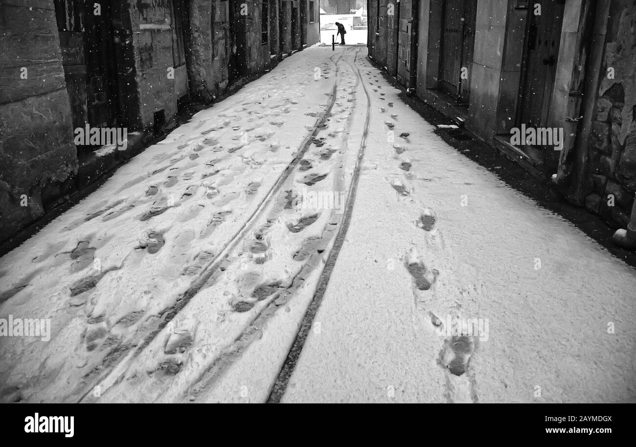 Man sweeping snow from urban street, winter and work Stock Photo - Alamy
