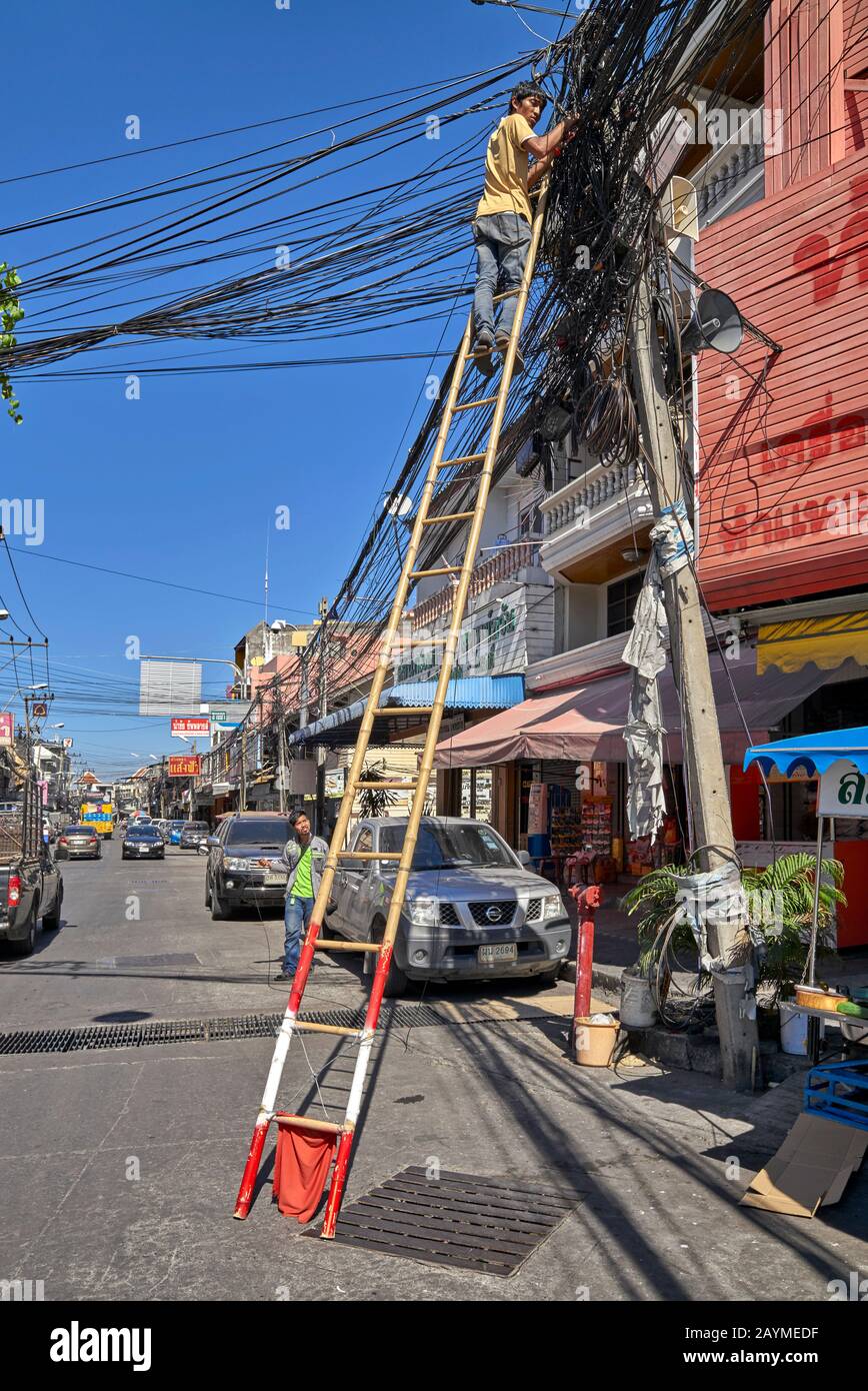 Lineman working overhead amongst amidst a myriad of wires and ...