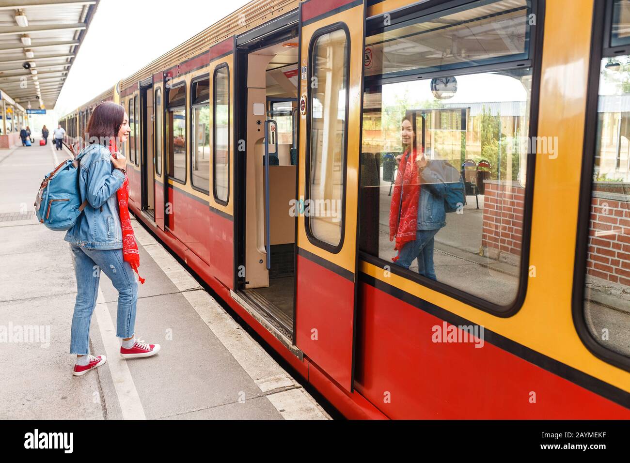 Pretty young tourist woman boarding a train Stock Photo - Alamy