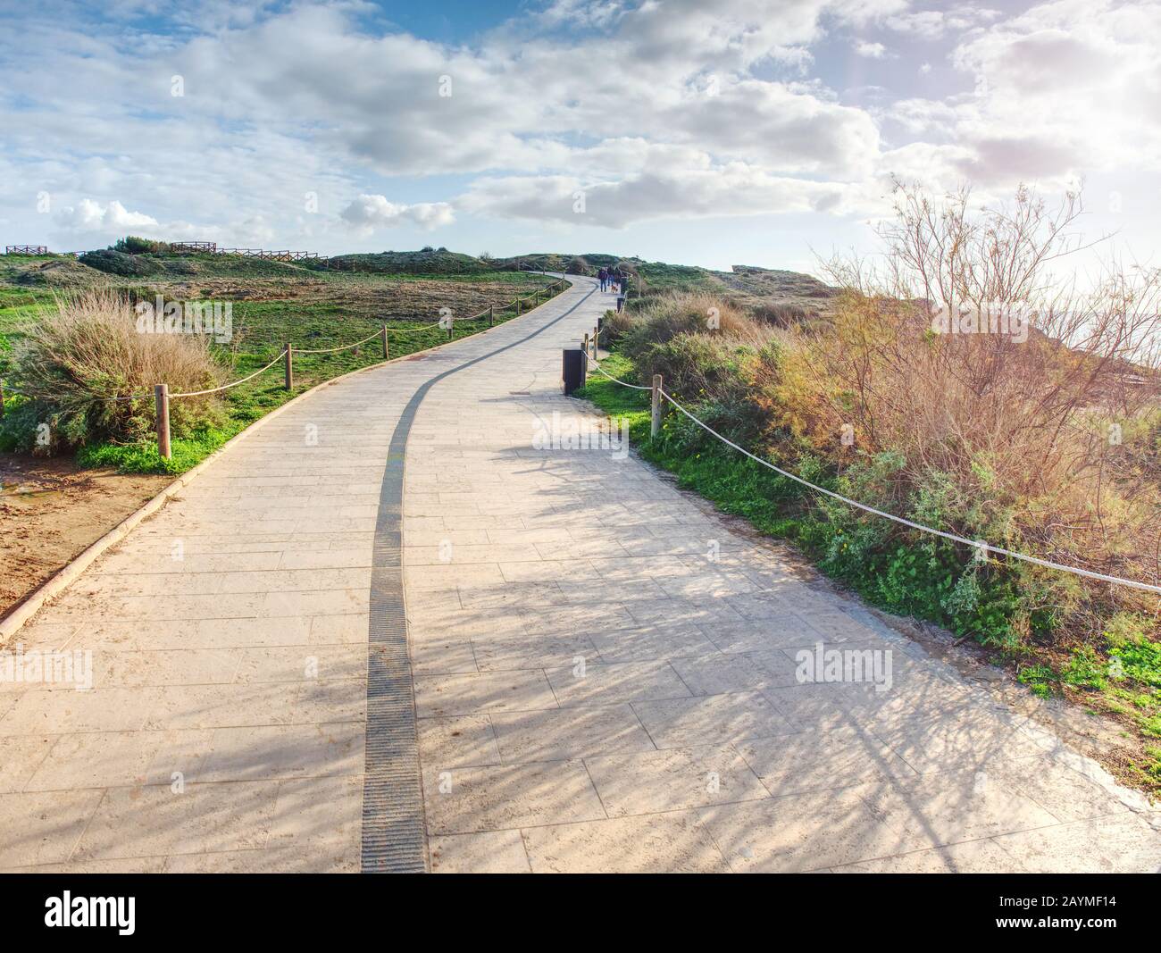Stony tilled paved footpath at sea, dark stripe in middle divide parts ...
