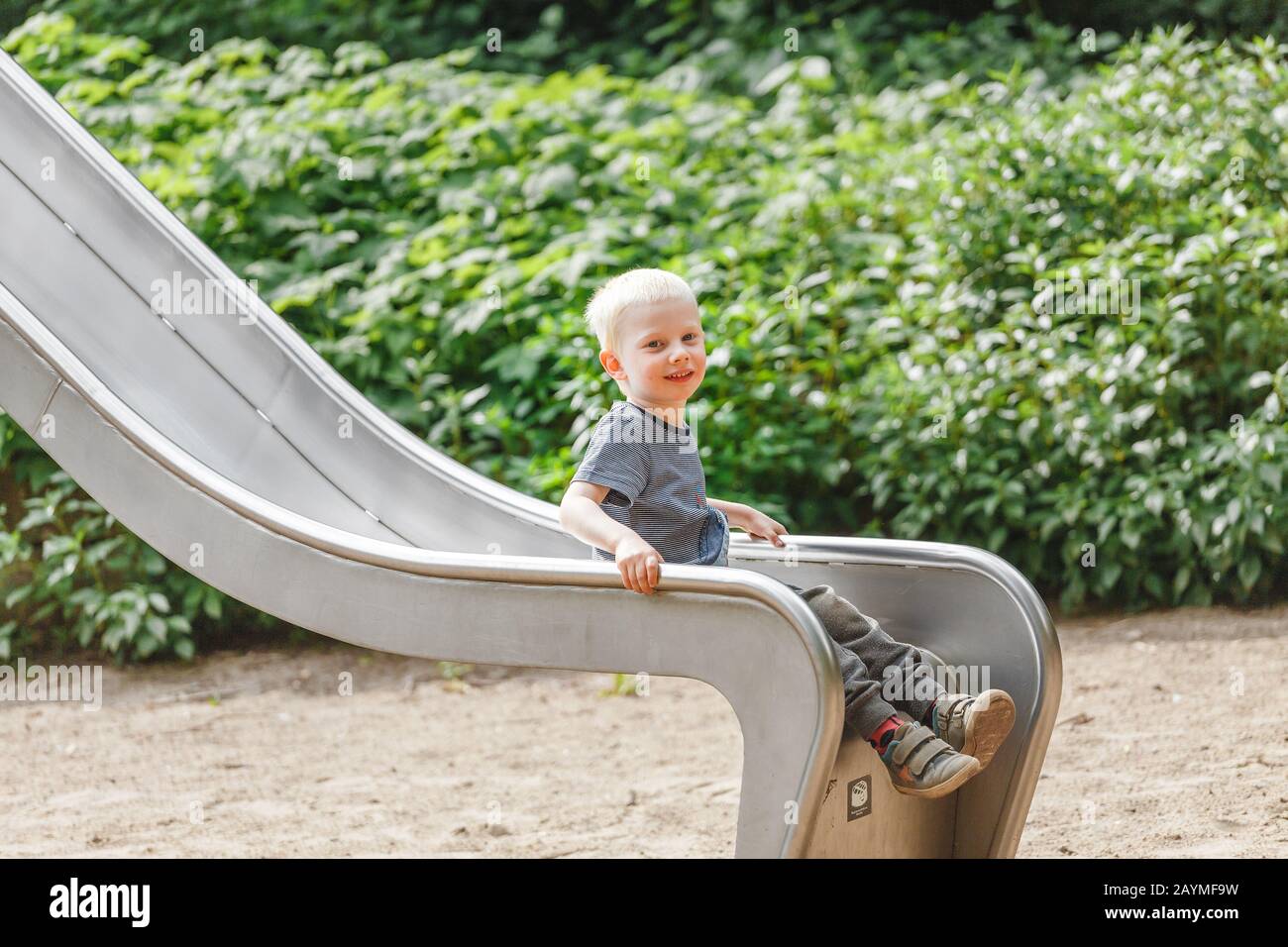 16 MAY 2018, BERLIN, GERMANY: Happy kid playing on a slide at a ...