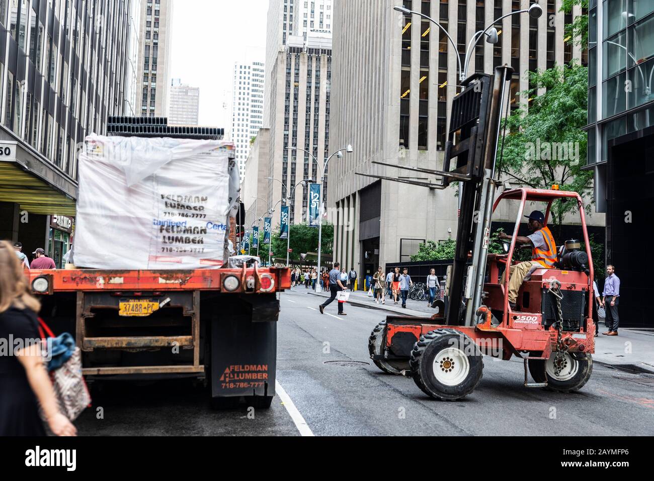 New York City, USA - August 3, 2018: Truck unloading container with a ...
