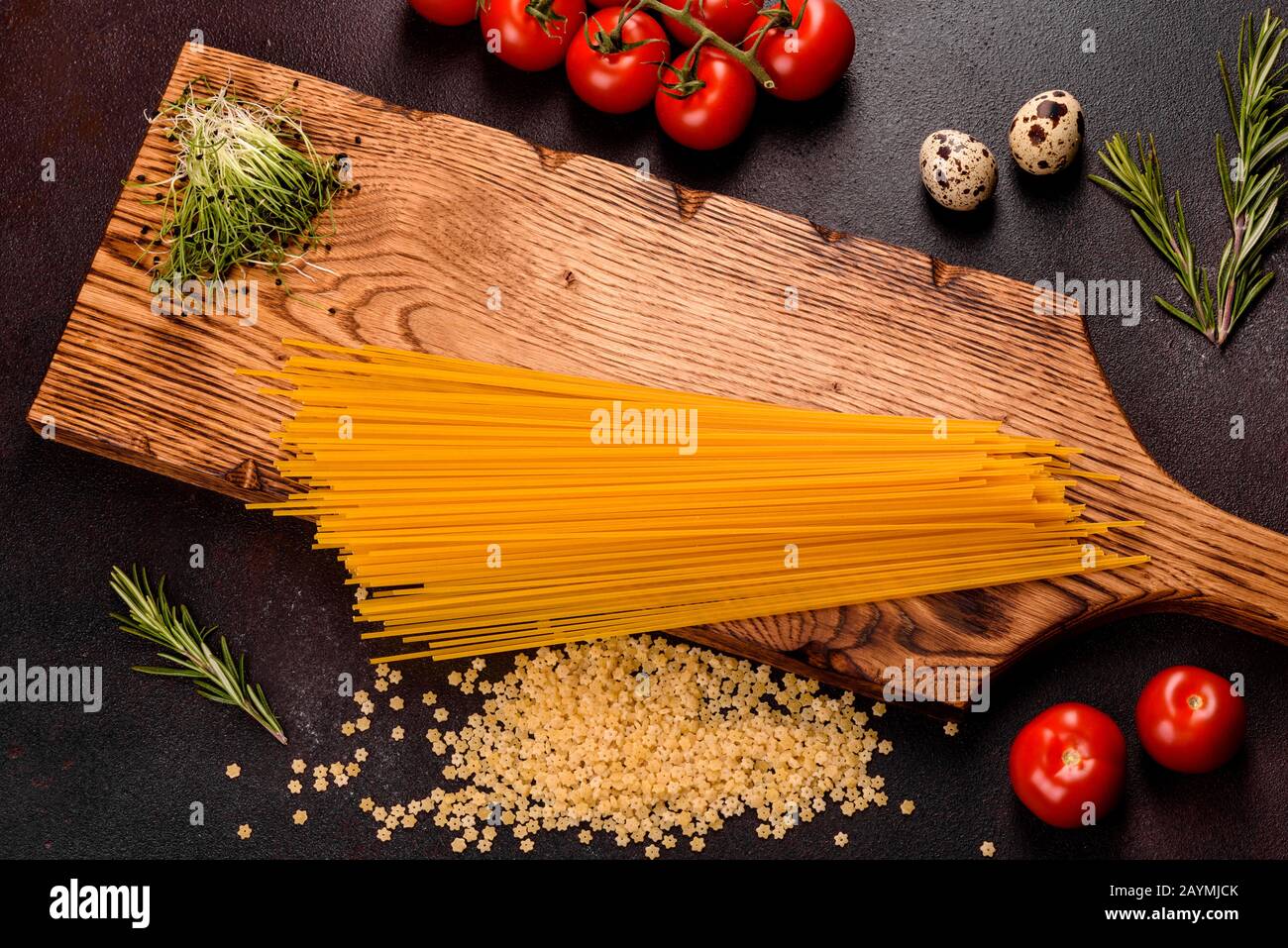 Ingredients for cooking paste on a dark background. Cherry tomatoes ...