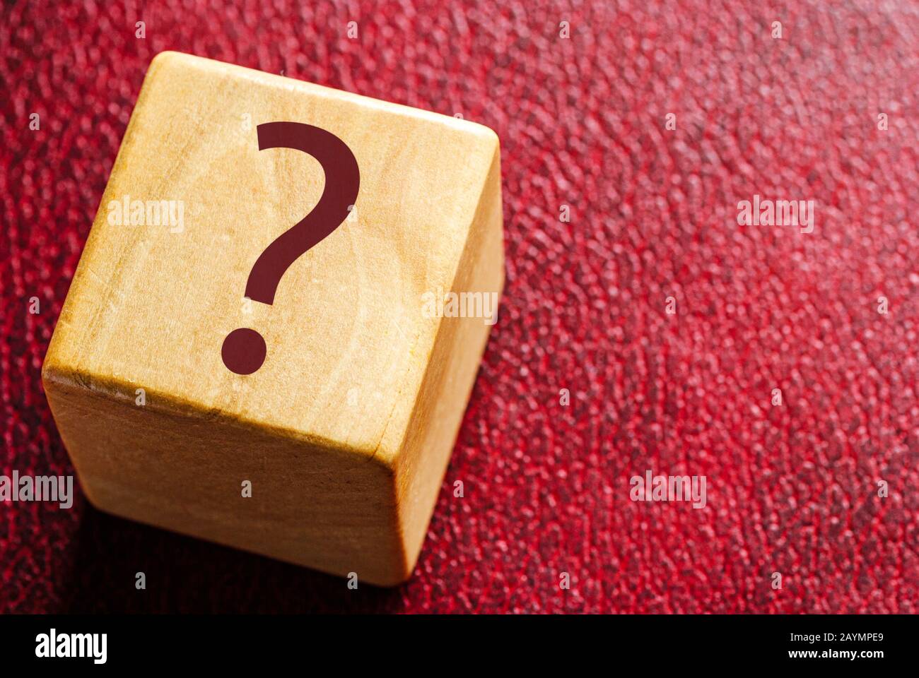 Wooden cube with question mark on red leather Stock Photo - Alamy