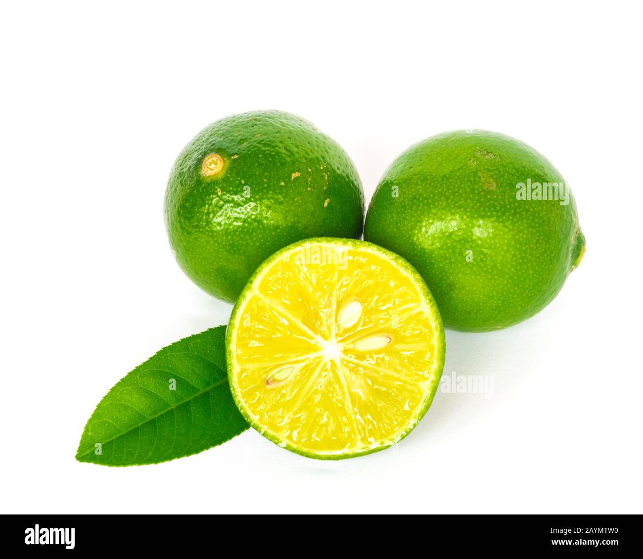 Two homegrown raw Asian limes with half cut slices and green leaves ...