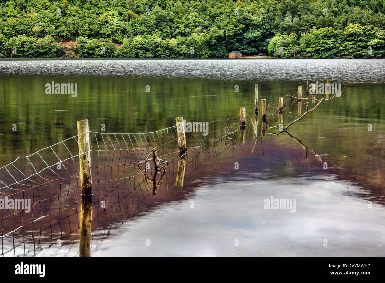 A submerged fence with a boathouse in the distance, Crummock Water ...
