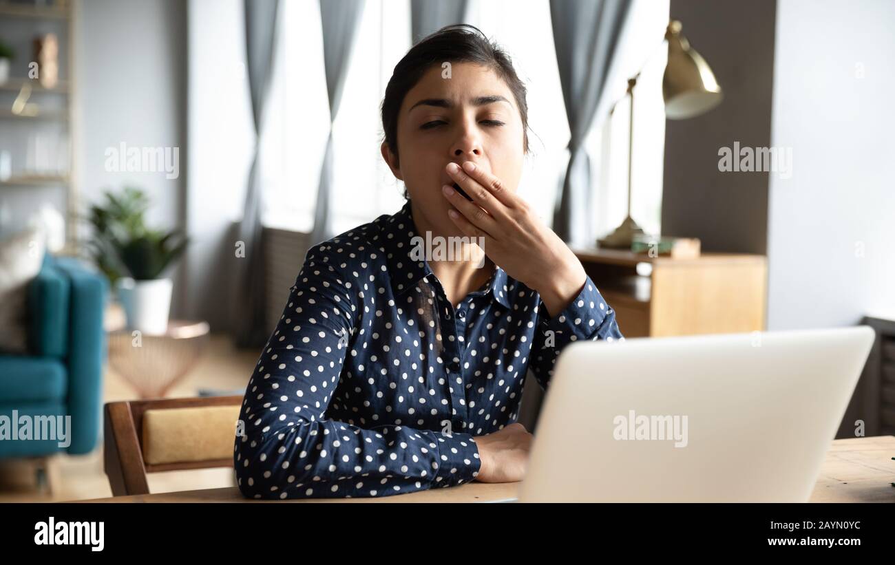 Tired ethnic woman yawn sigh at workplace Stock Photo - Alamy