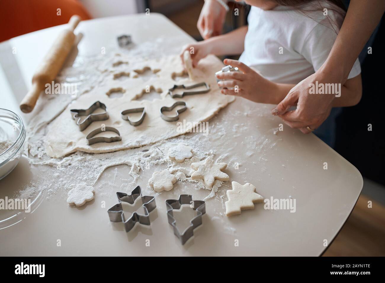 child using cookie cutter in the kitchen, closeup cropped side view ...
