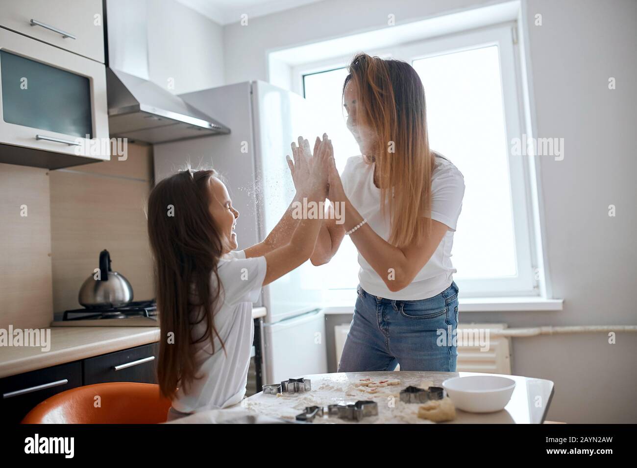 happy mommy and her daughter laughinhg, touhing hands, palms, rejoicing ...