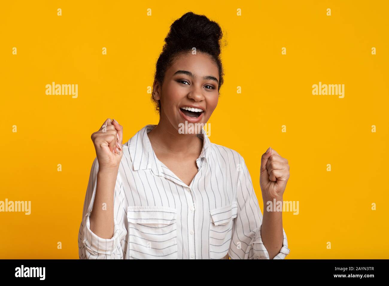 Happy Afro Girl Celebrating Victory, Shaking Fists Over Yellow ...