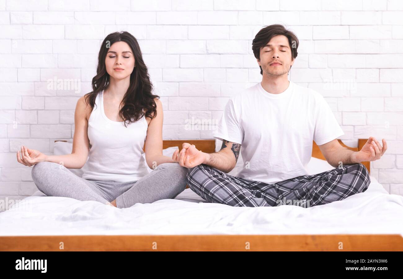 Calm married couple meditating together at home Stock Photo - Alamy