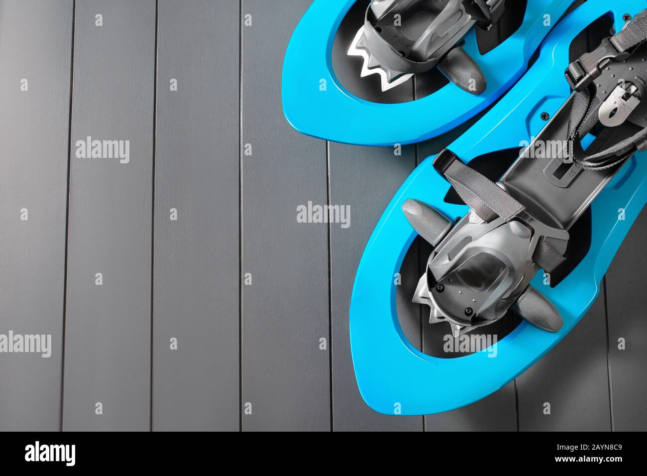 Colorful blue snowshoes studio shot on wooden background with copy ...