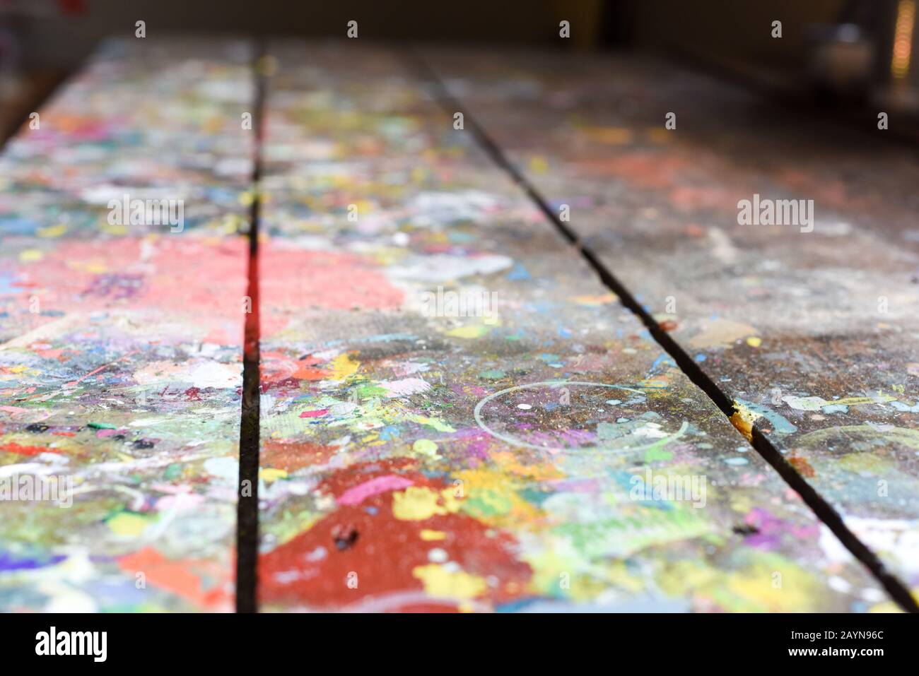 Artists workshop or studio bench covered with splattered paint built up ...