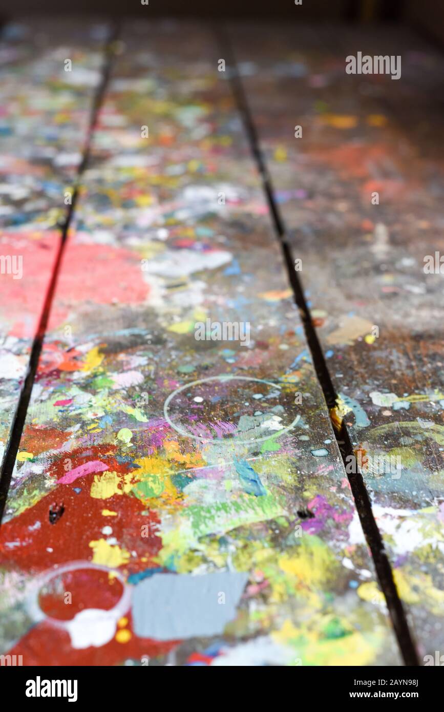 Artists workshop or studio bench covered with splattered paint built up ...