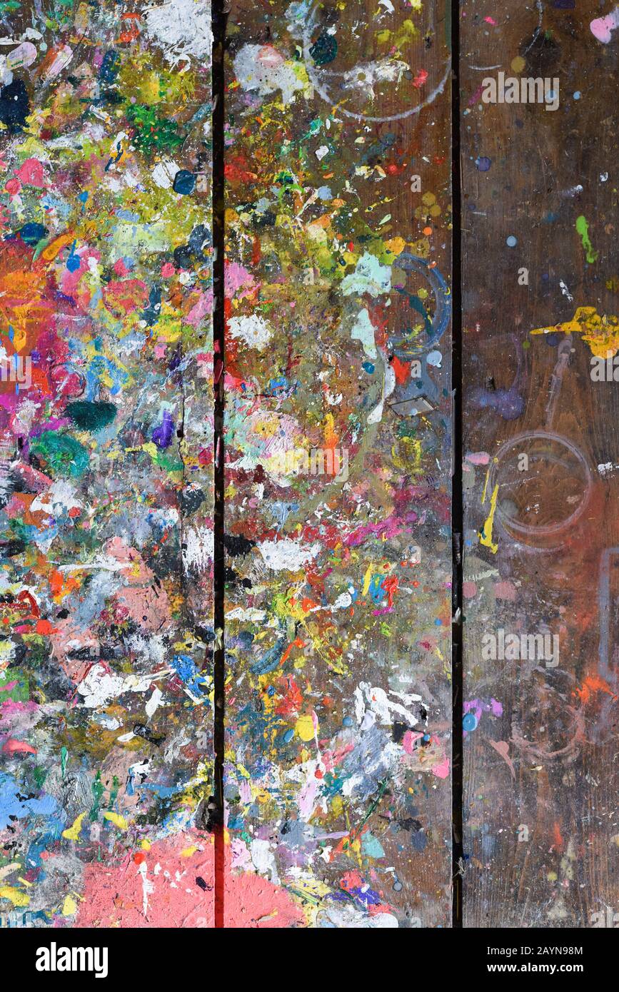 Artists workshop or studio bench covered with splattered paint built up ...